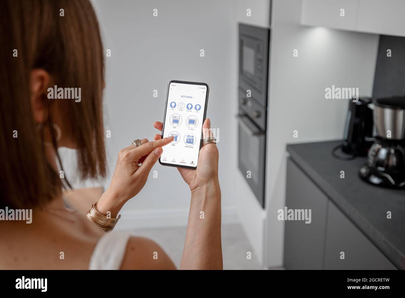 Controlling smart devices with phone on the kitchen Stock Photo - Alamy