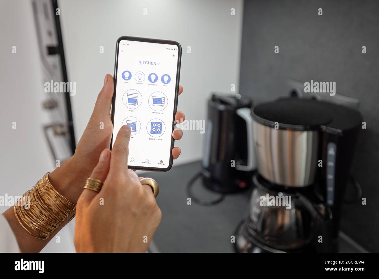 Controlling smart devices with phone on the kitchen Stock Photo - Alamy