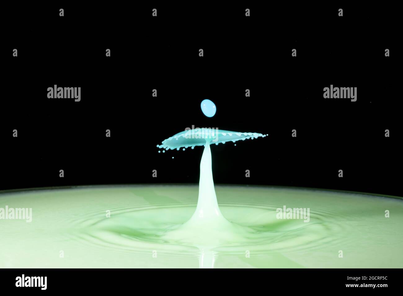 Close-up photograph of two water droplets colliding making an unusual ...