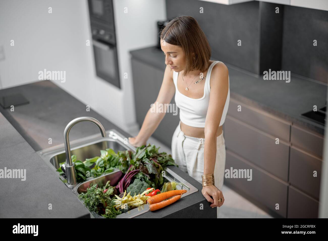 Woman washing fresh vegetables and greens in the sink Stock Photo - Alamy