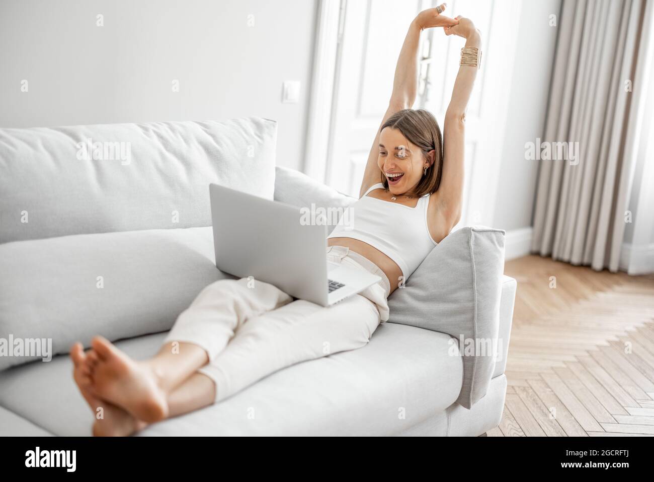 Relaxed woman works on laptop from cozy home Stock Photo - Alamy