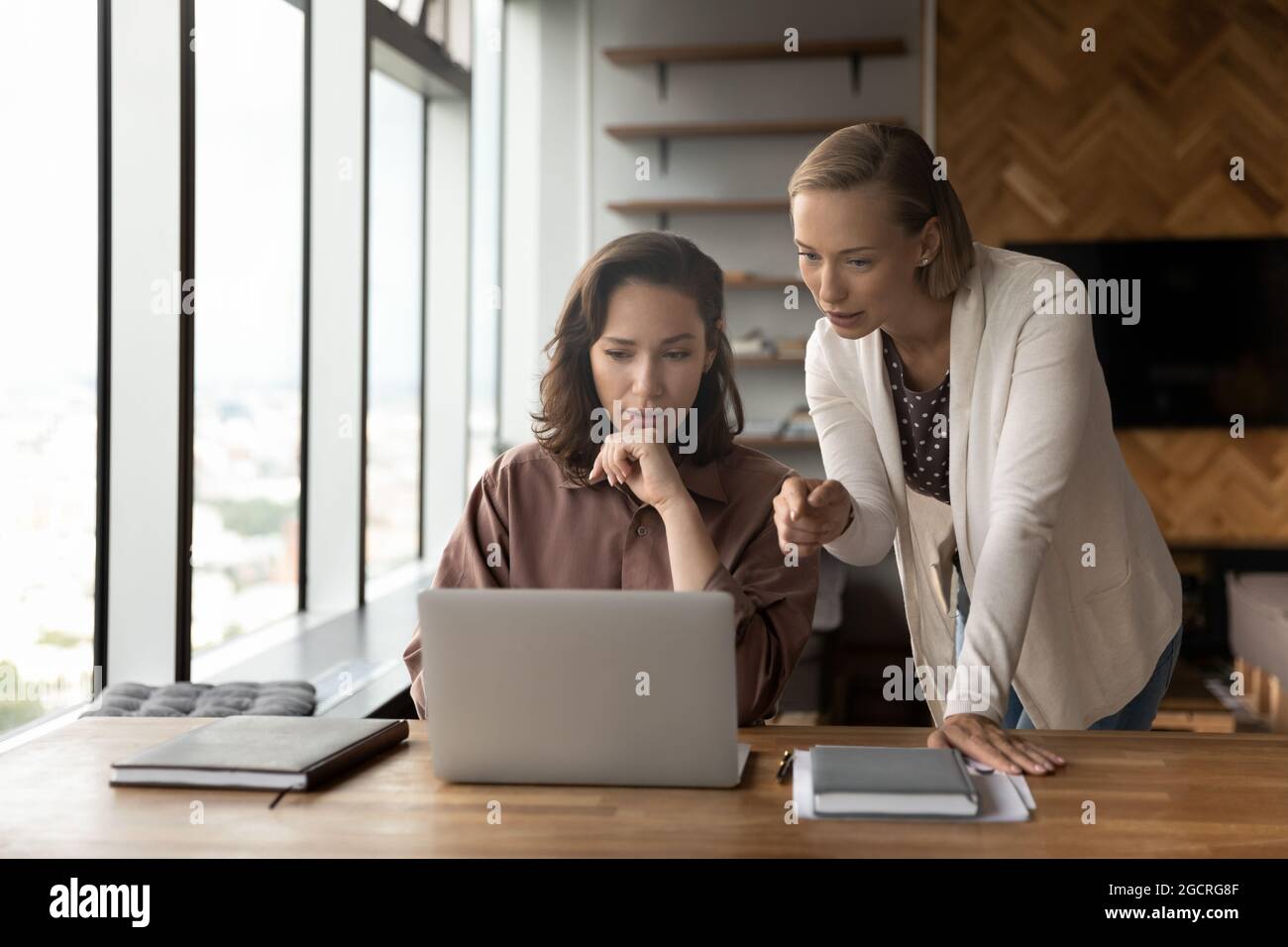 Corporate mentor supervising work of intern, giving help Stock Photo ...