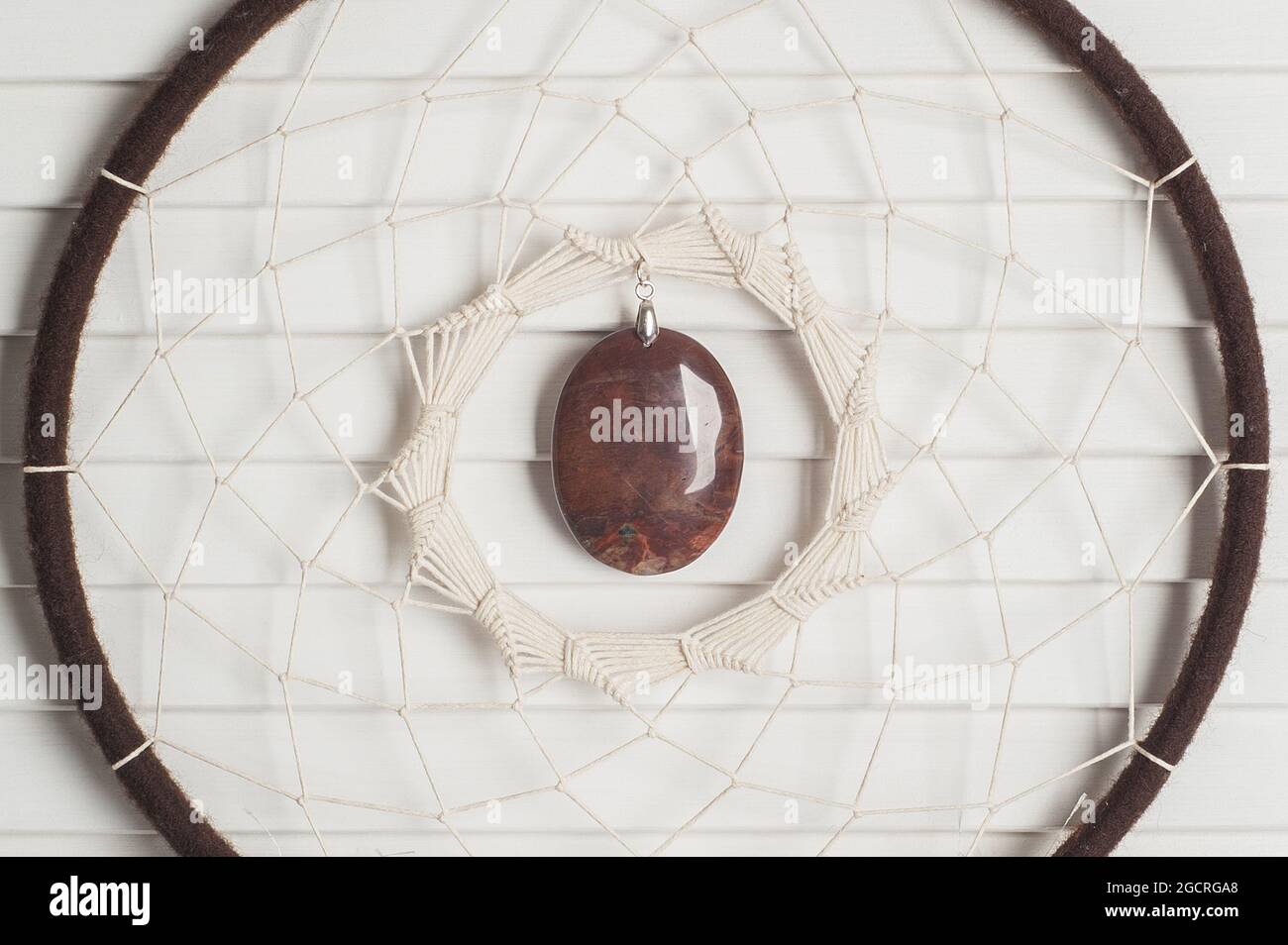 Dream catcher with jasper closeup on white wooden background in bedroom ...