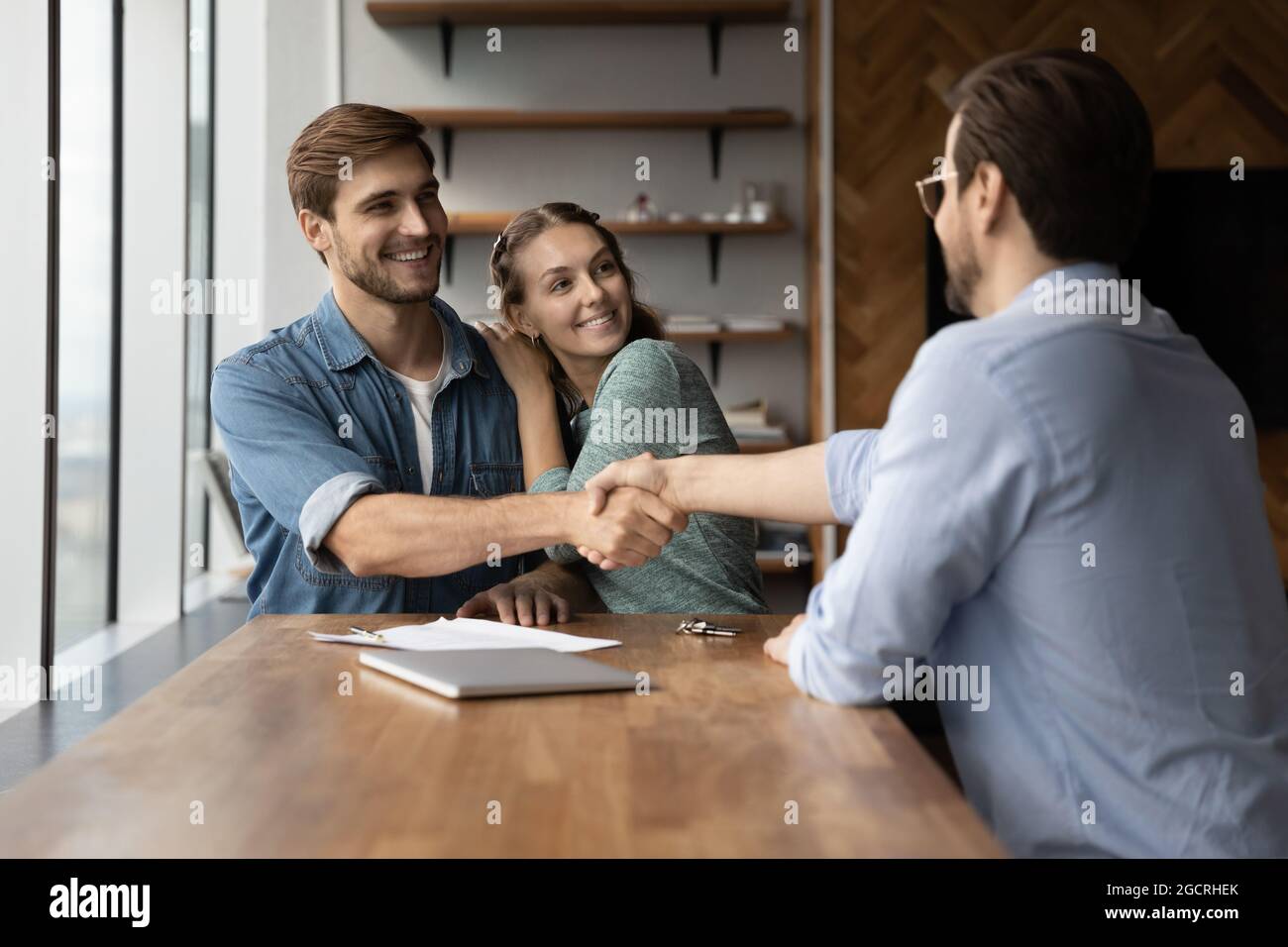 Happy excited couple of clients and lawyer giving handshakes Stock ...