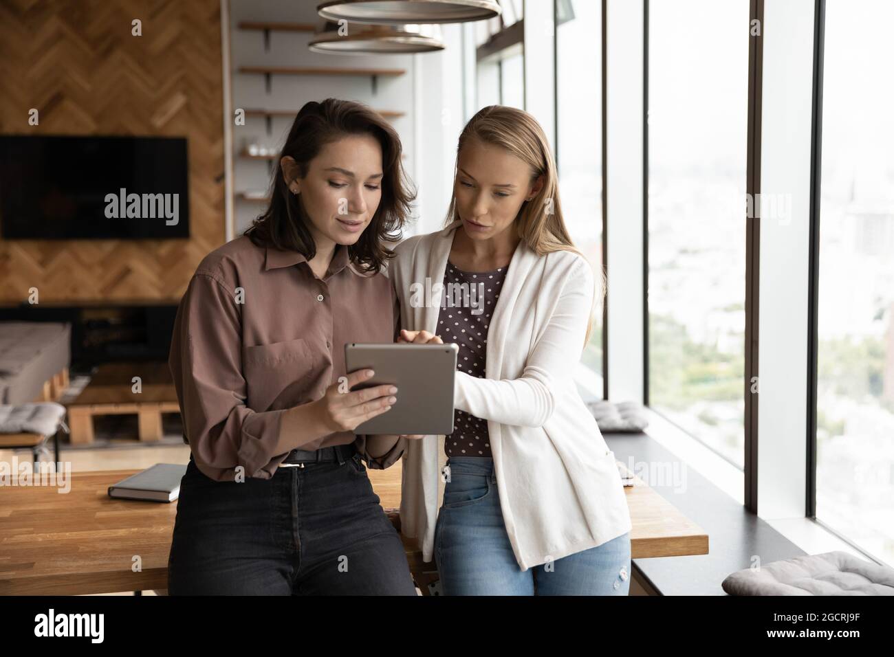 Female office employee showing work content on tablet Stock Photo - Alamy