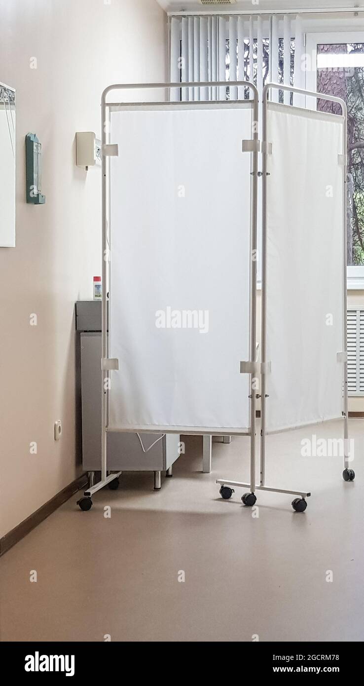 Interior of a bright doctor's office with a folding screen, vertical ...