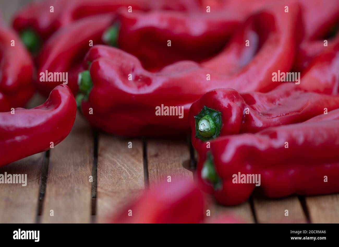 Group of red peppers on wooden table Stock Photo - Alamy