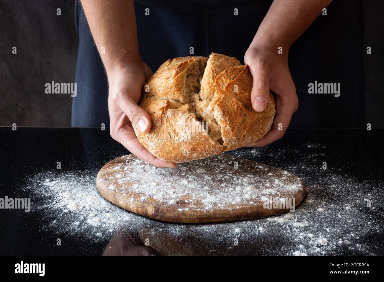 Freshly organic baked Bread is being ripped by Baker in Bakery on a ...