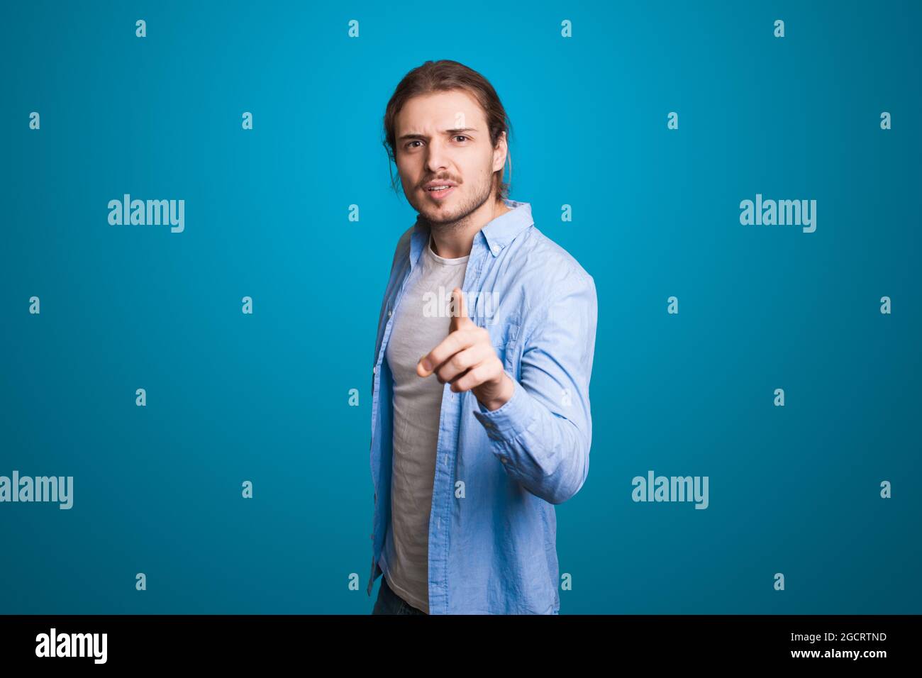 Stylish portrait of man point at you on blue background. Man pointing ...