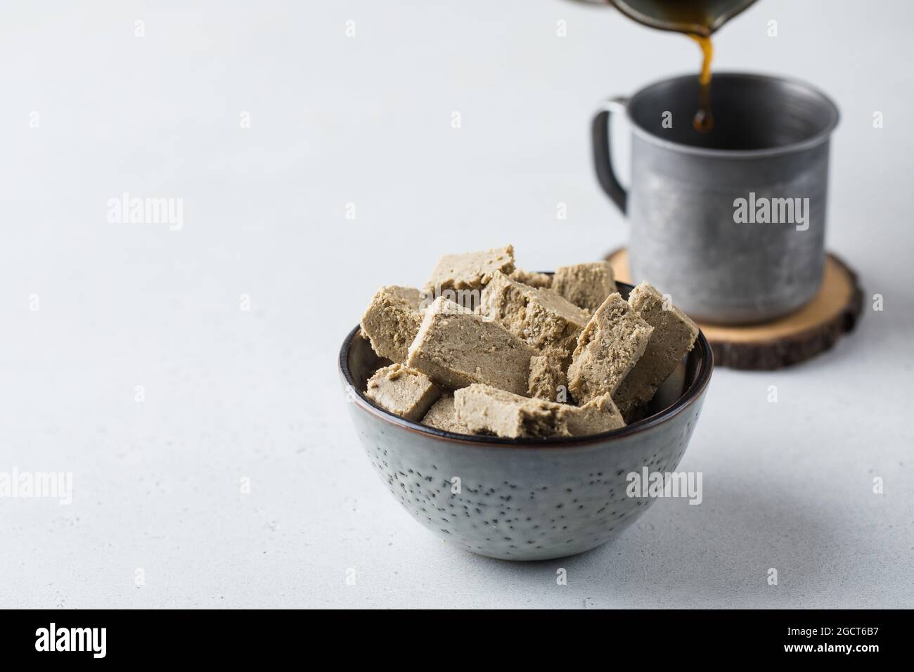 Pieces of halva in bowl and coffee from turka are poured into a mug ...