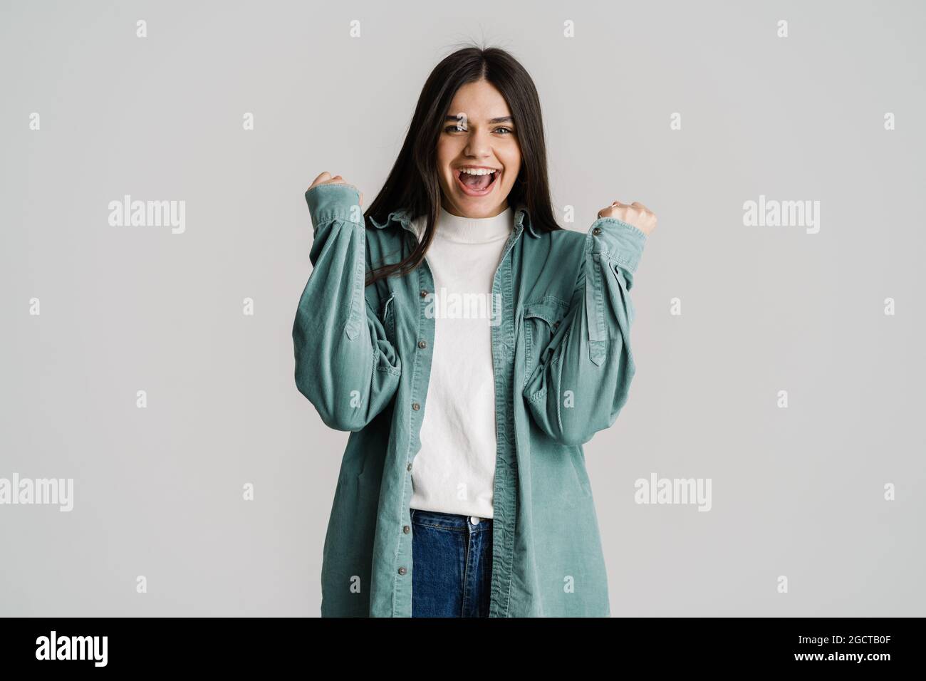 Young excited woman screaming while making winner gesture isolated over ...