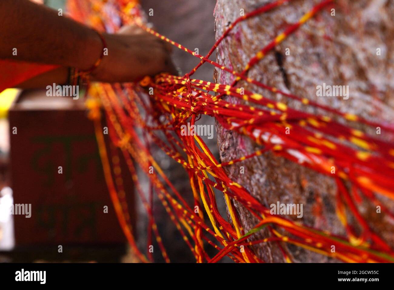 An Indian Hindu offers prayers as ties a sacred thread to a ...