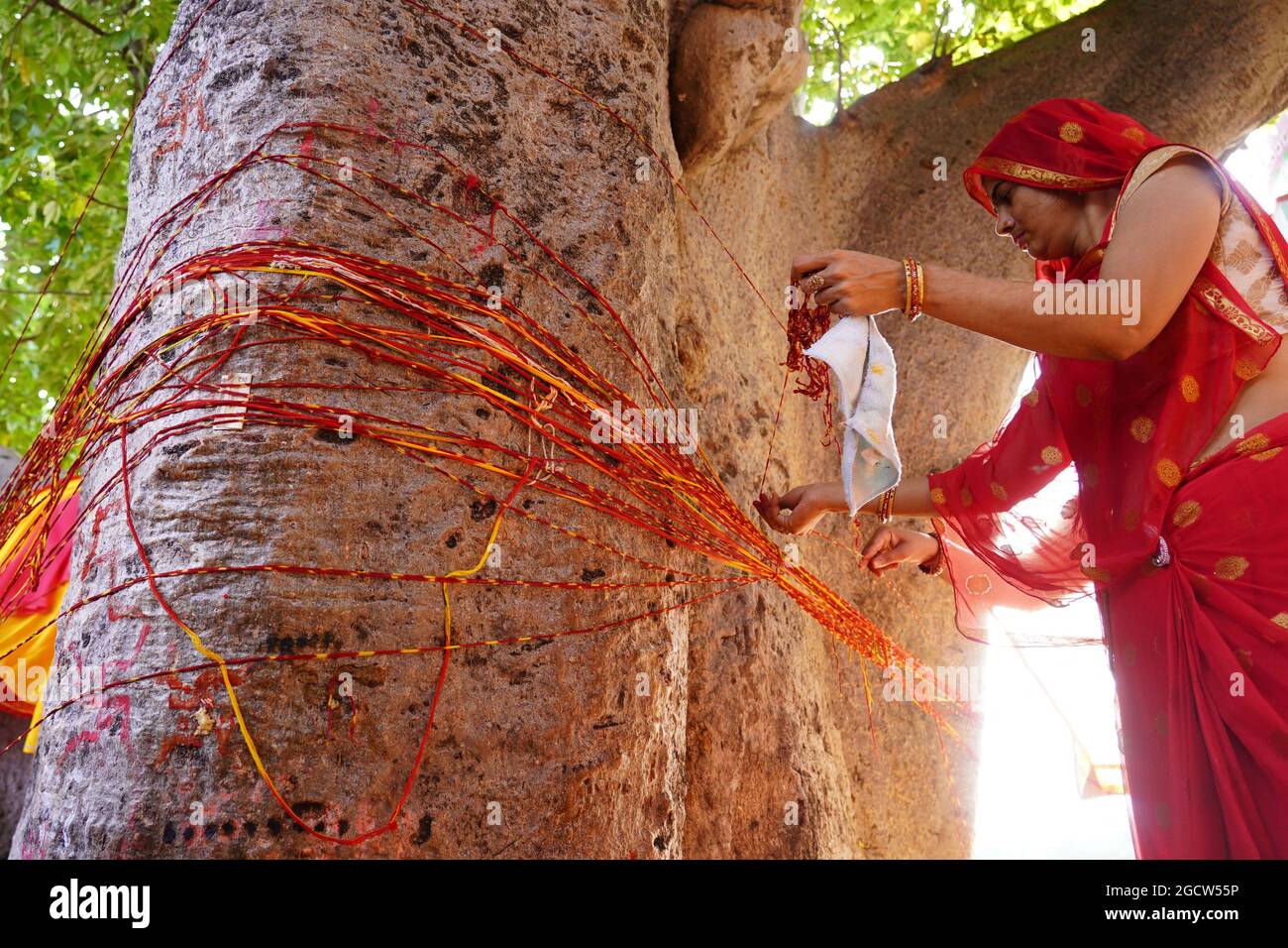 An Indian Hindu offers prayers as ties a sacred thread to a ...