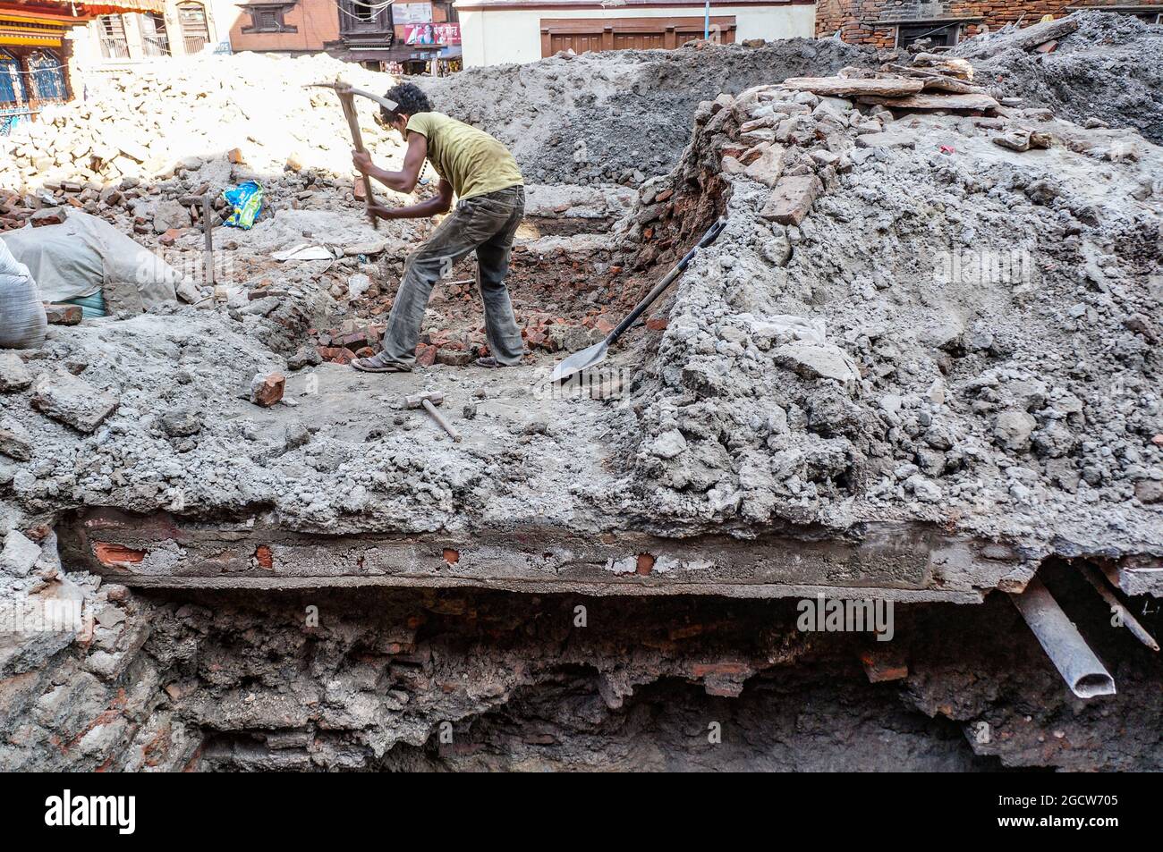 A man clearing rubble with a pickaxe in the aftermath of the April 2015 ...