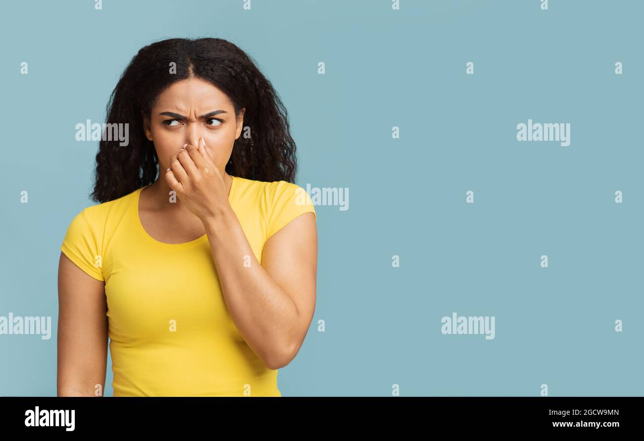 African american woman closing nose with fingers, feeling unpleasant ...