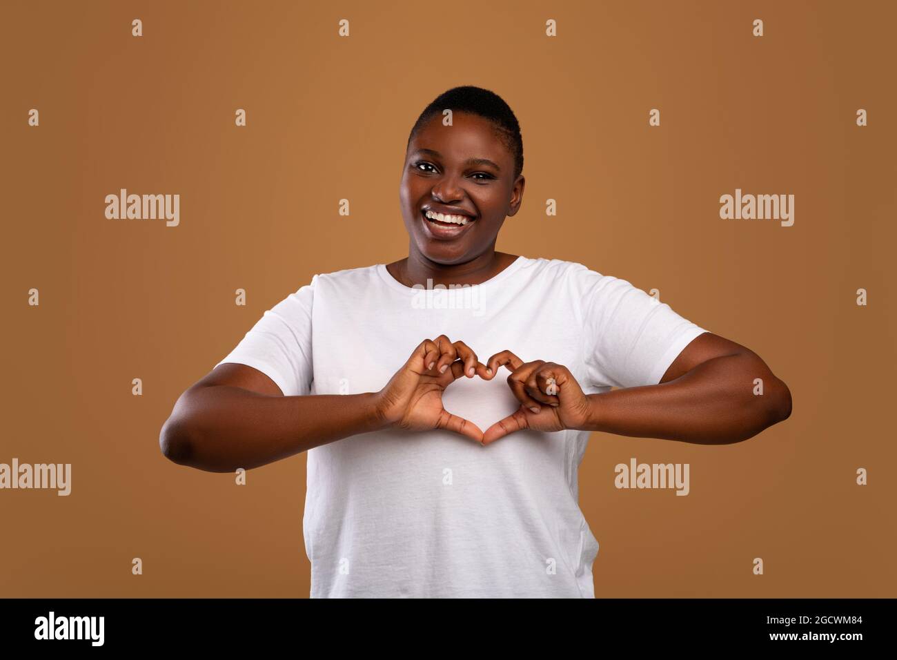 Portrait of casual young black woman shaping hands like heart Stock ...