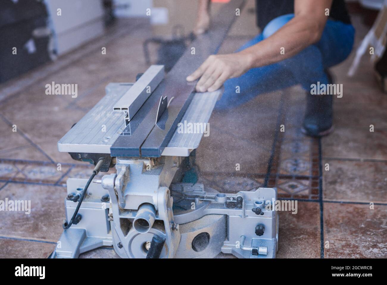 Unprotected hands of a man cutting a plank with an electric disc Stock ...