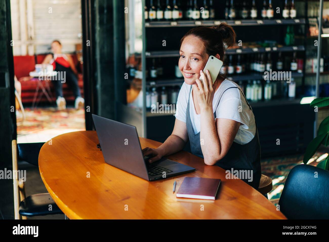 Woman manager talking on the phone while sitting in a cafe with a ...
