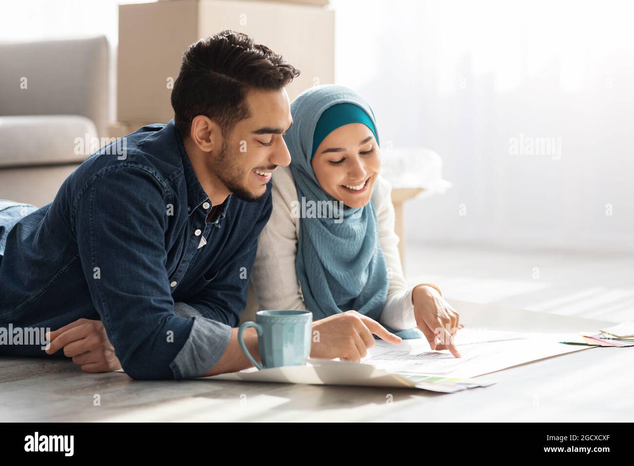 Creative muslim family laying on floor with apartment scheme Stock ...