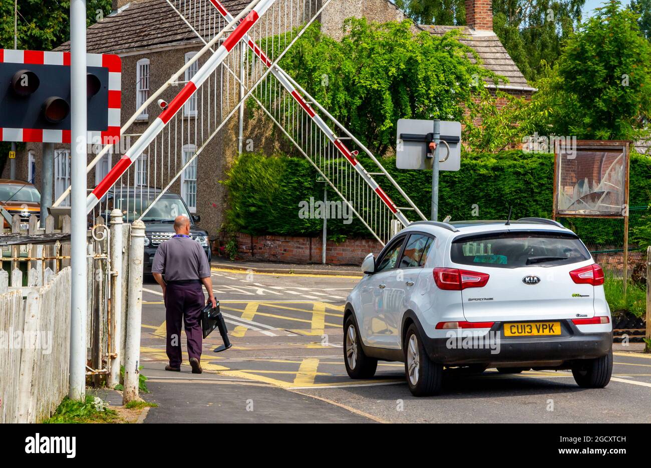 Car and gates at automated level crossing on a railway line at ...