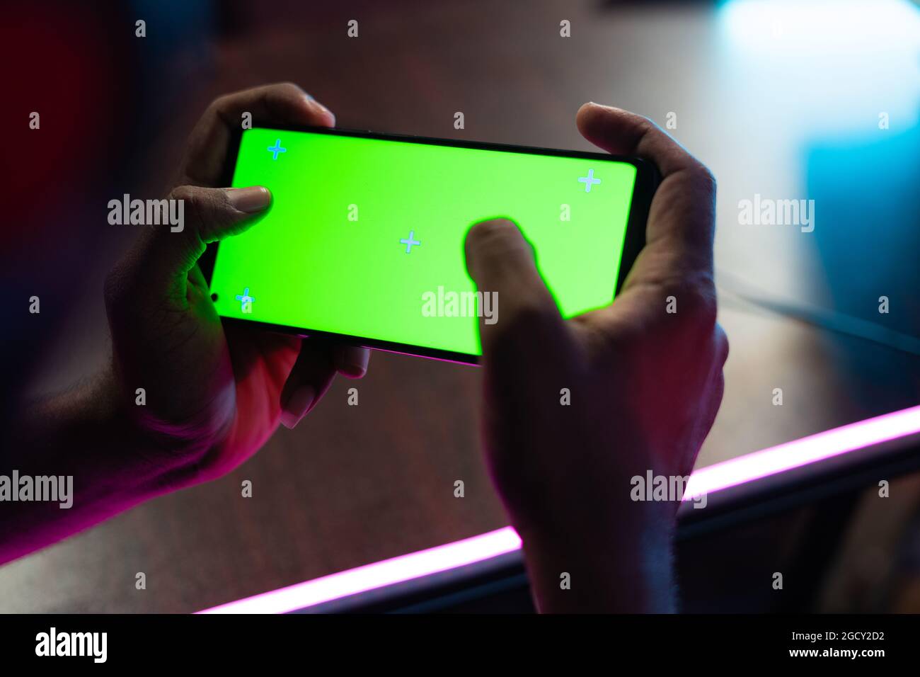 Shoulder shot first person view of gamer playing video game on green ...