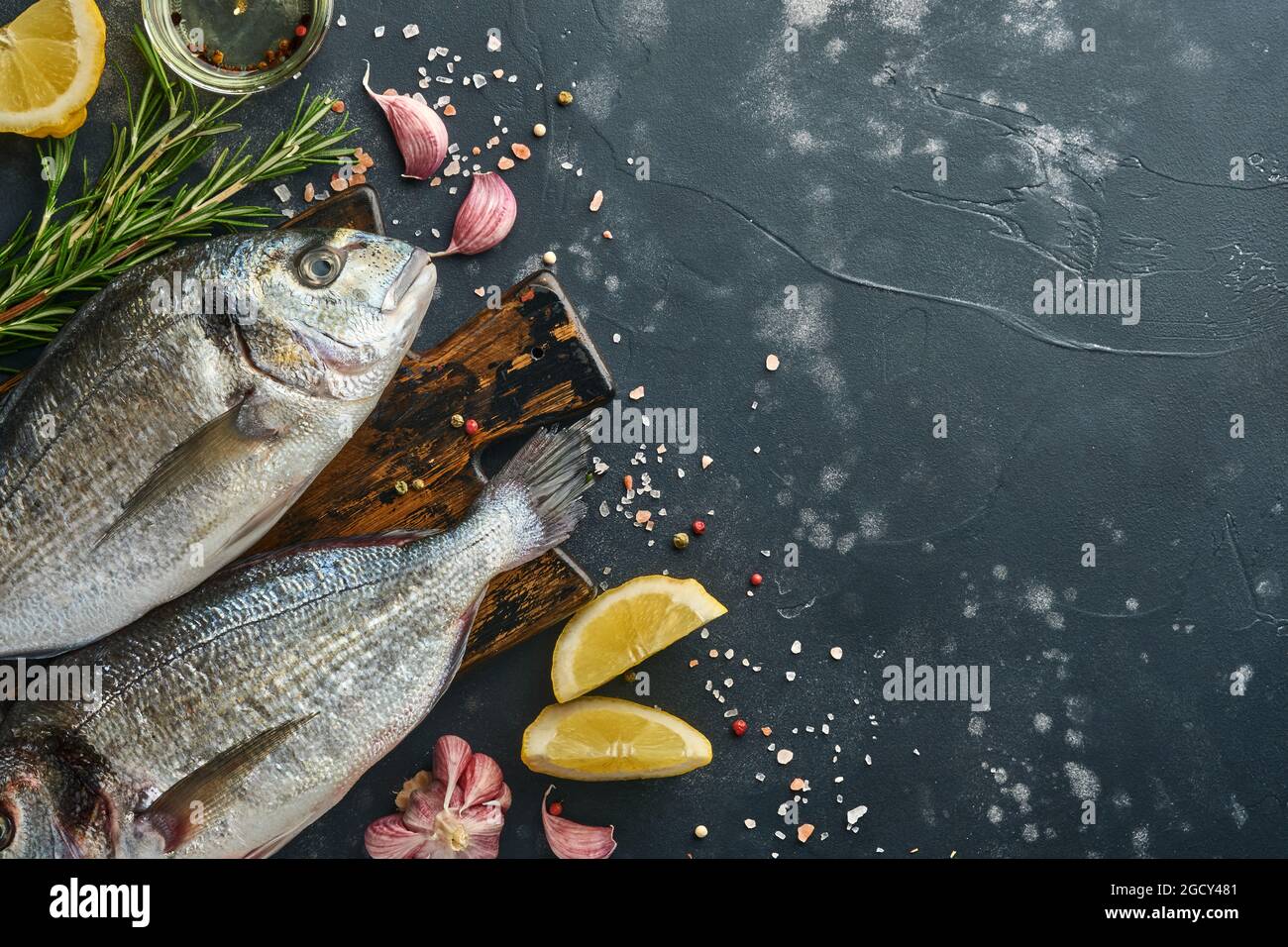 Raw dorado fresh fish or sea bream with ingredients for making lemon ...