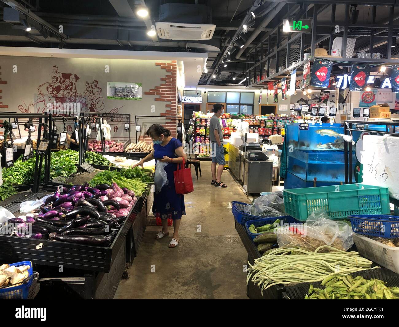 Chengdu, China. 10th Aug, 2021. People shop for food at a food market ...