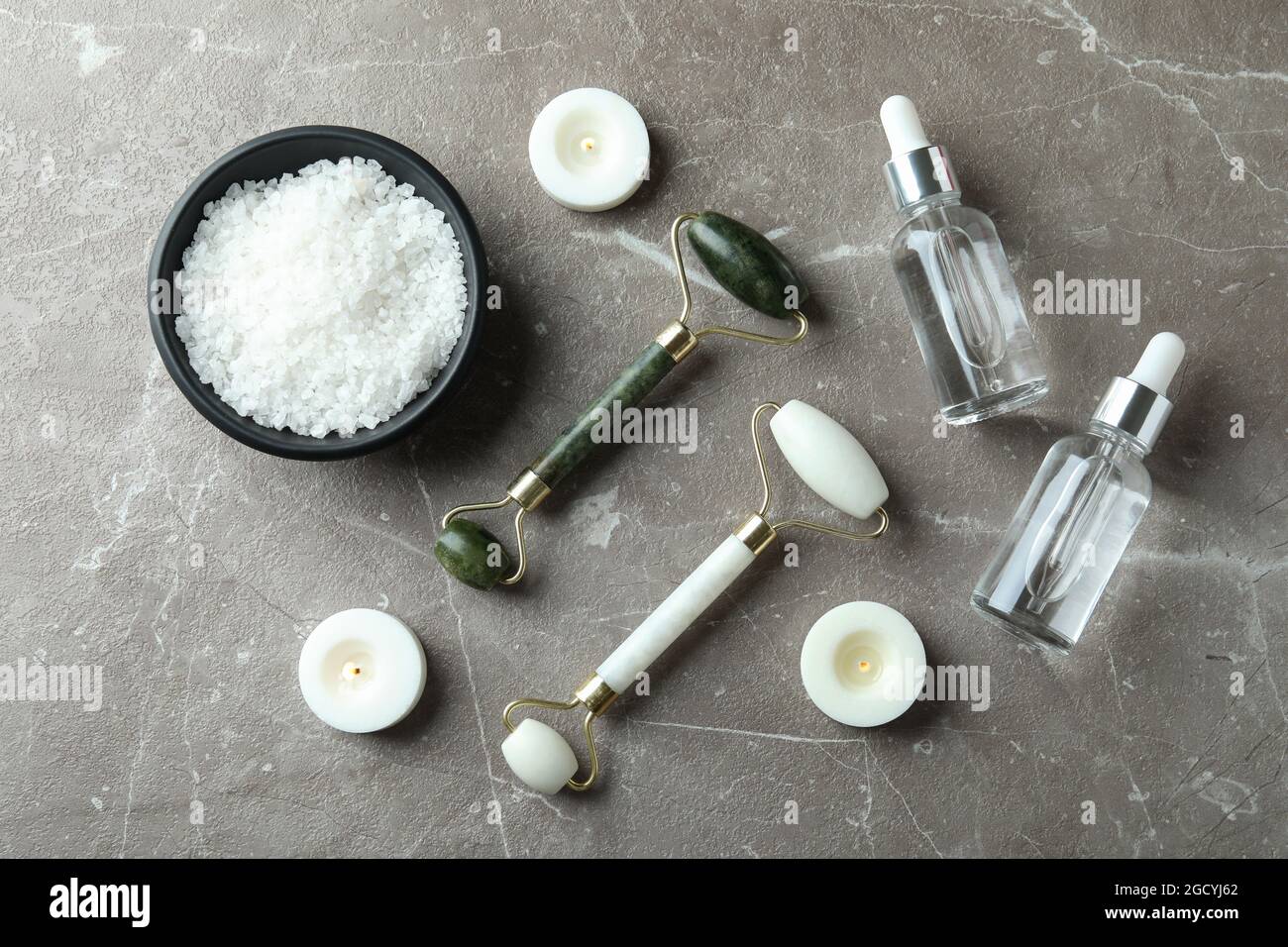 Skin care concept with face rollers on gray textured table Stock Photo ...
