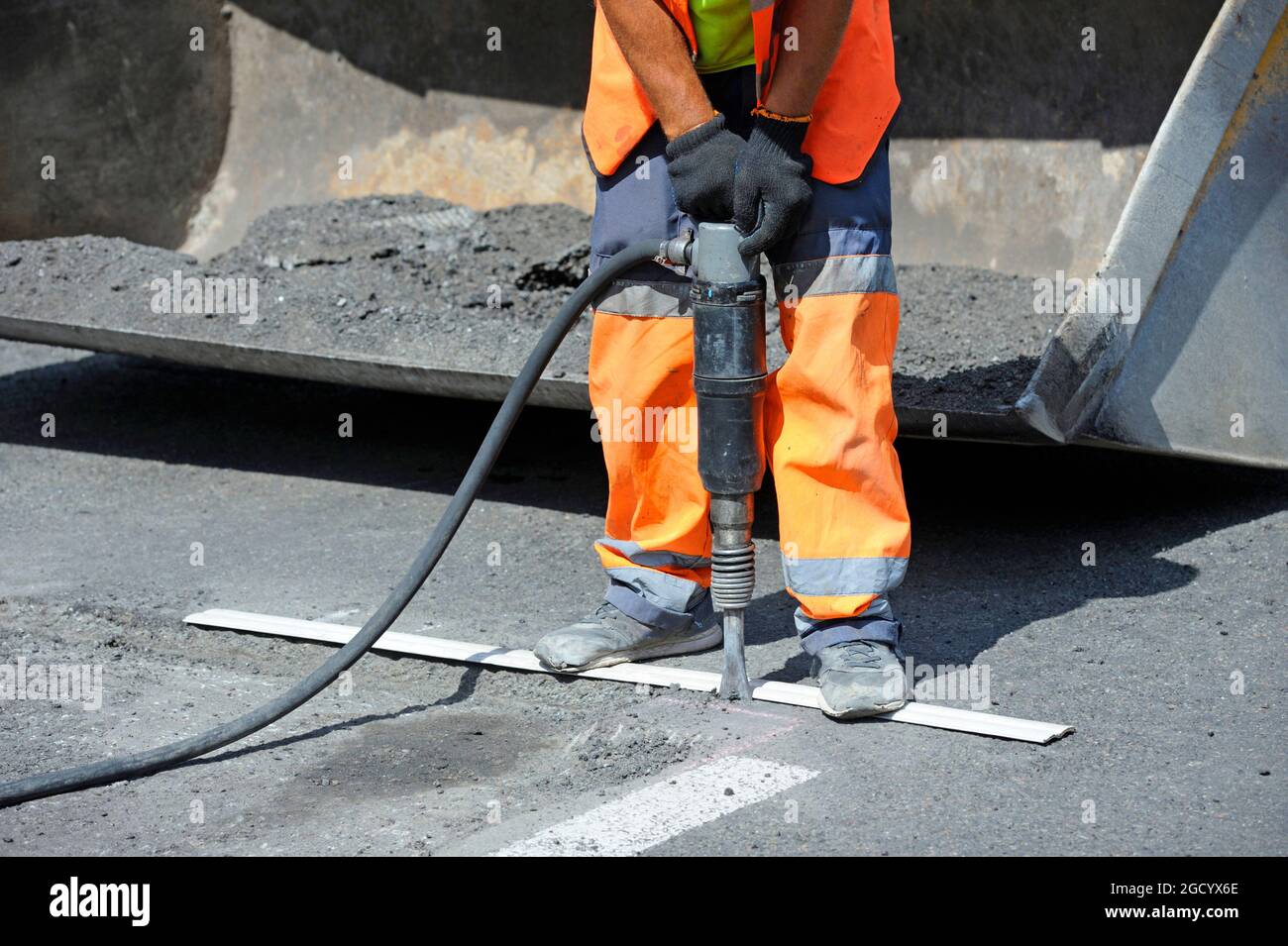 Worker preparing lay for asphalting the road using pneumatic road ...