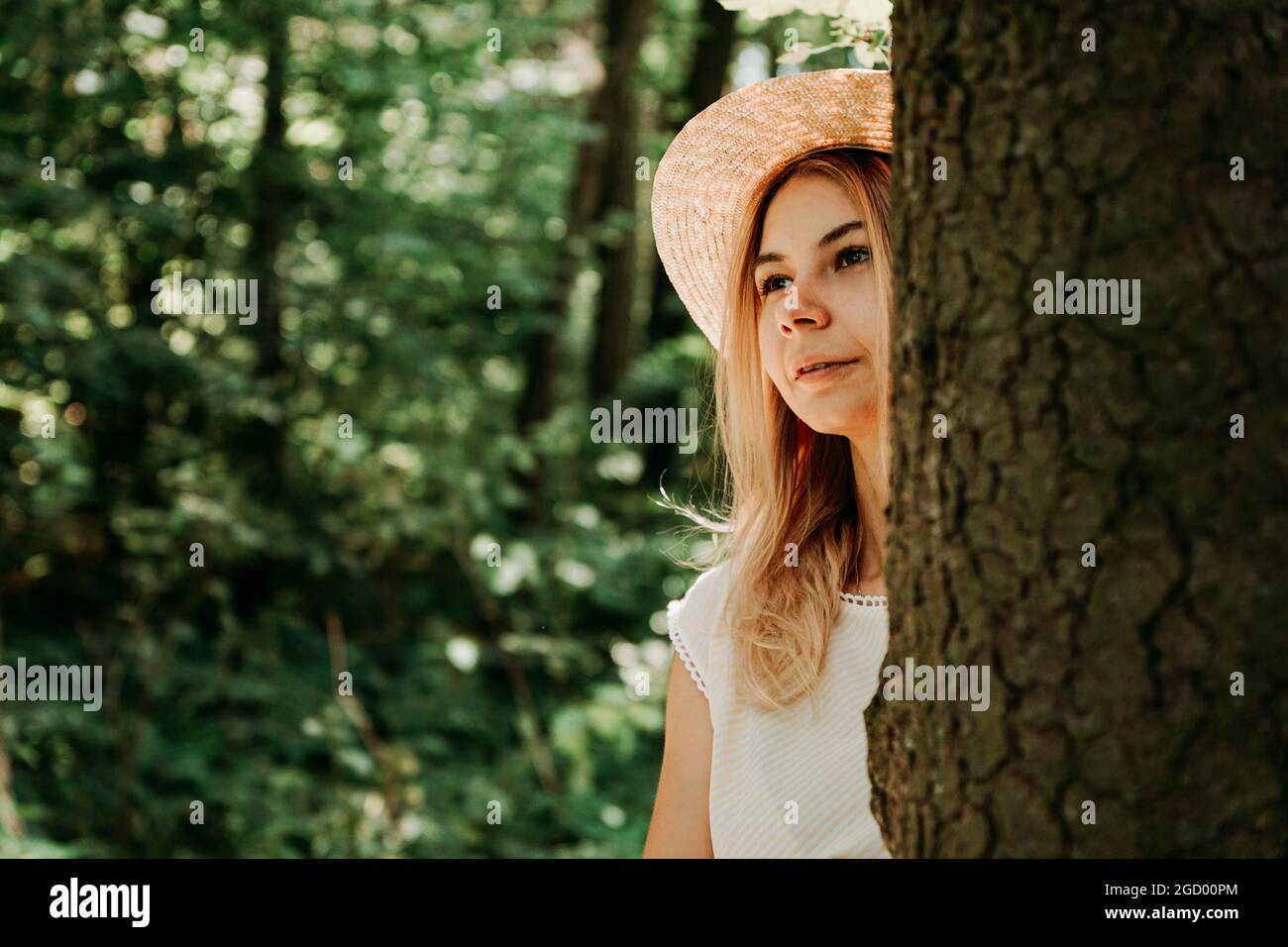 Portrait Of A Young Girl In The Forest She Peeks Out From Behind A