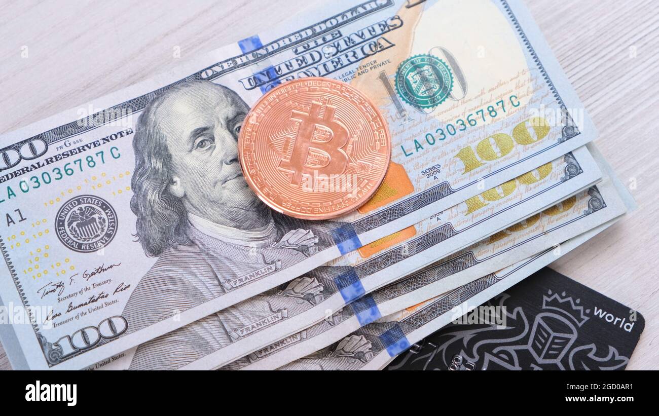 cryptocurrency Bitcoin and a credit card and one hundred dollar bills ...