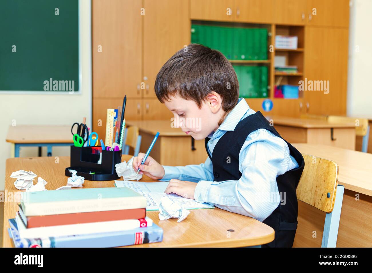 Serious schoolboy in the classroom. Primary school student. Back to ...