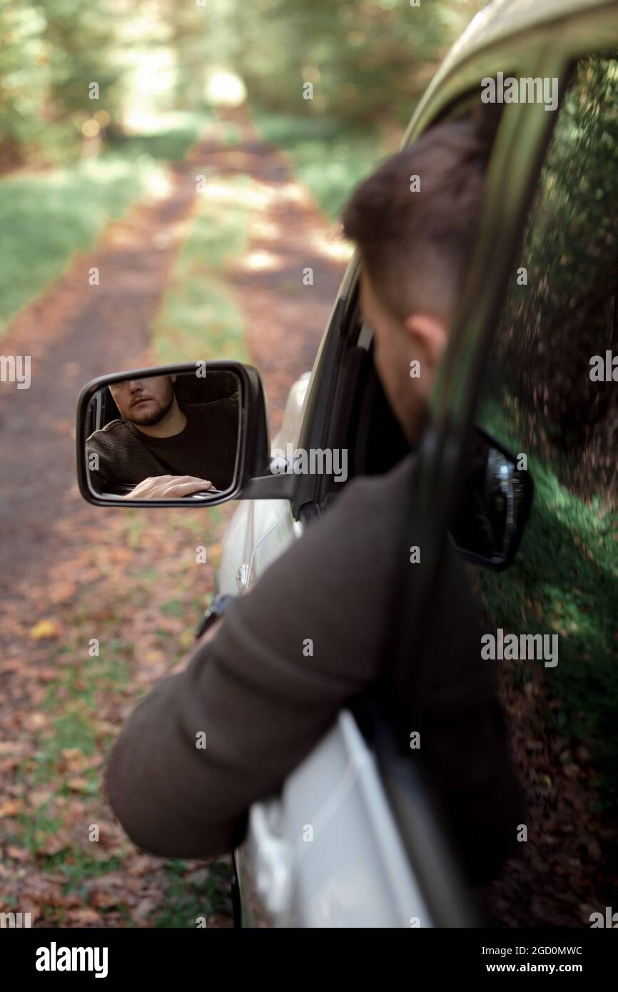 portrait of a man stick out of car window at forest trail Stock Photo ...