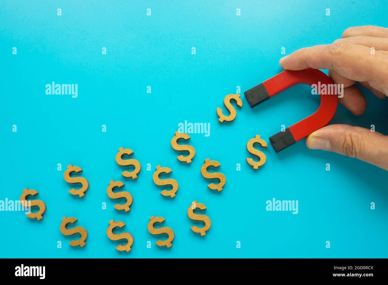 Money attracting concept. Hand holds magnet and dollar symbols Stock ...