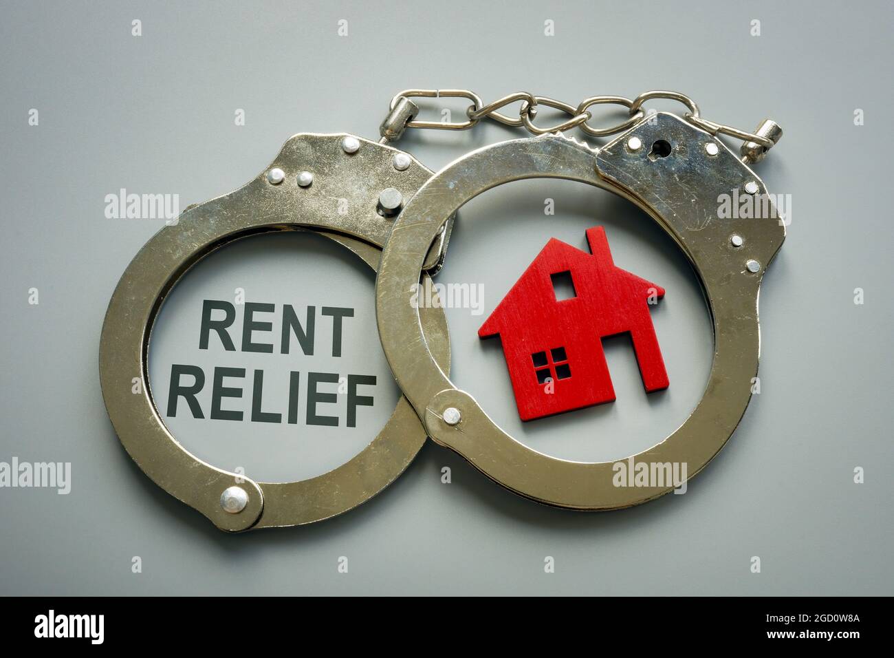 Rent relief concept. Handcuffs and model of house Stock Photo - Alamy