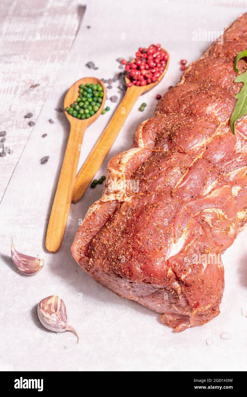 A piece of raw pork loin. Marinated fresh meat tied with culinary twine ...