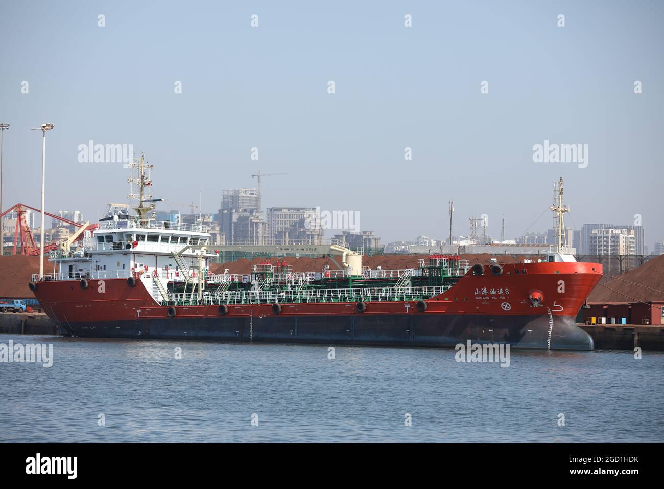 Ships and cargos are busy uploading and unloading goods by the deck of ...