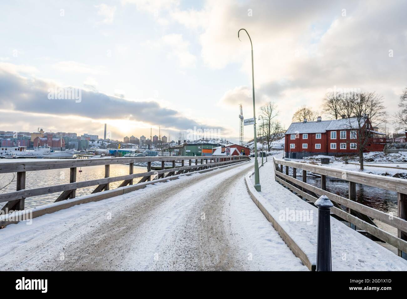 Beautiful snowy road surrounded by buildings under the cloudy shiny sky ...