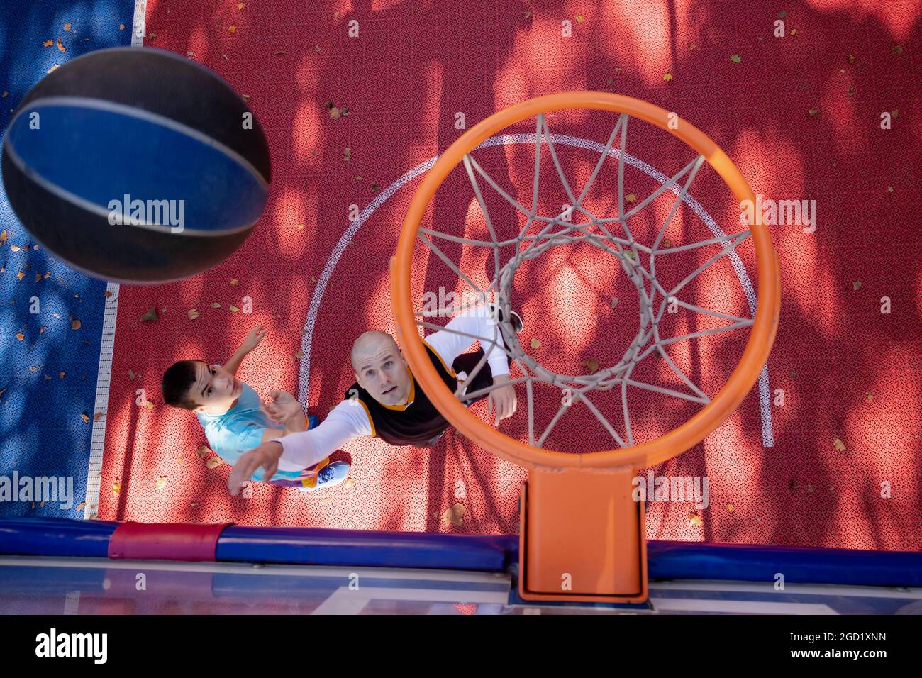 Brothers playing basketball One On One in the open court. Older brother ...