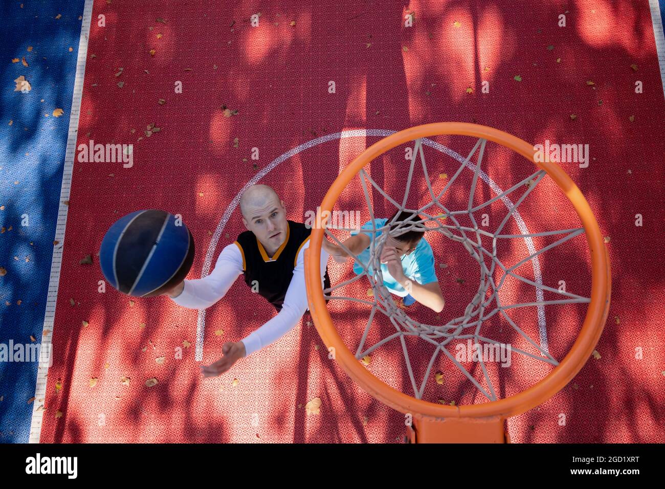 Brothers playing basketball One On One in the open court. Older brother ...