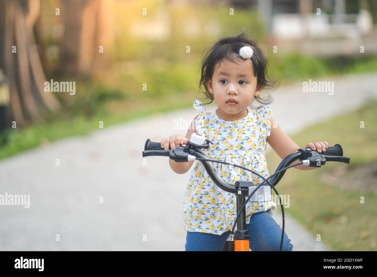 Cute Asian female child riding a bicycle Stock Photo - Alamy