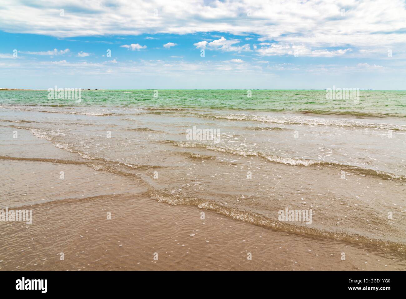 Empty sandy sea beach with small waves Stock Photo - Alamy
