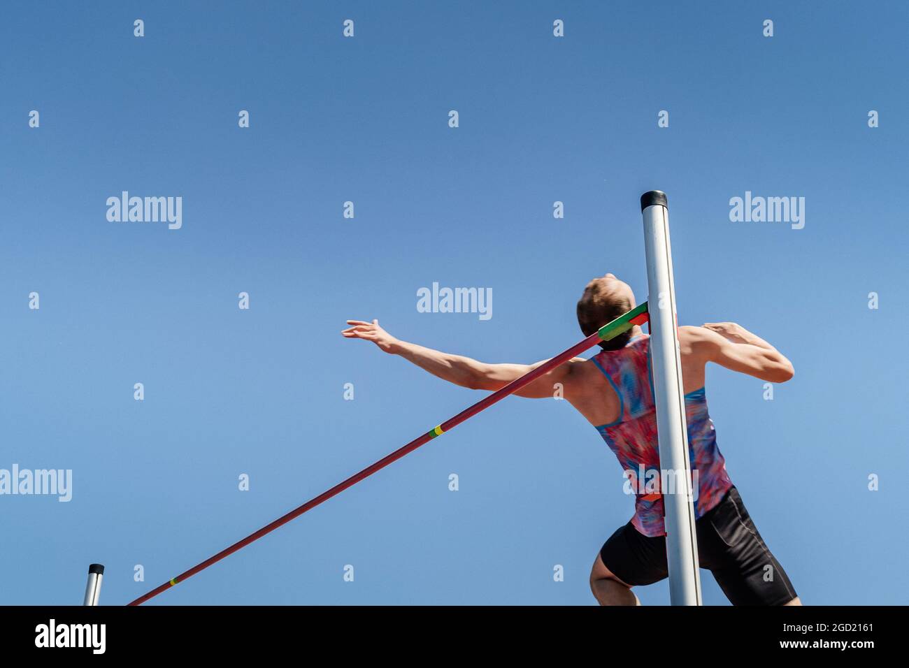 high jump male athlete on blue sky background Stock Photo - Alamy