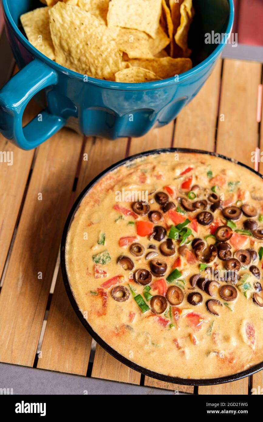 Tortilla chips with five layer queso cheese dip Stock Photo - Alamy