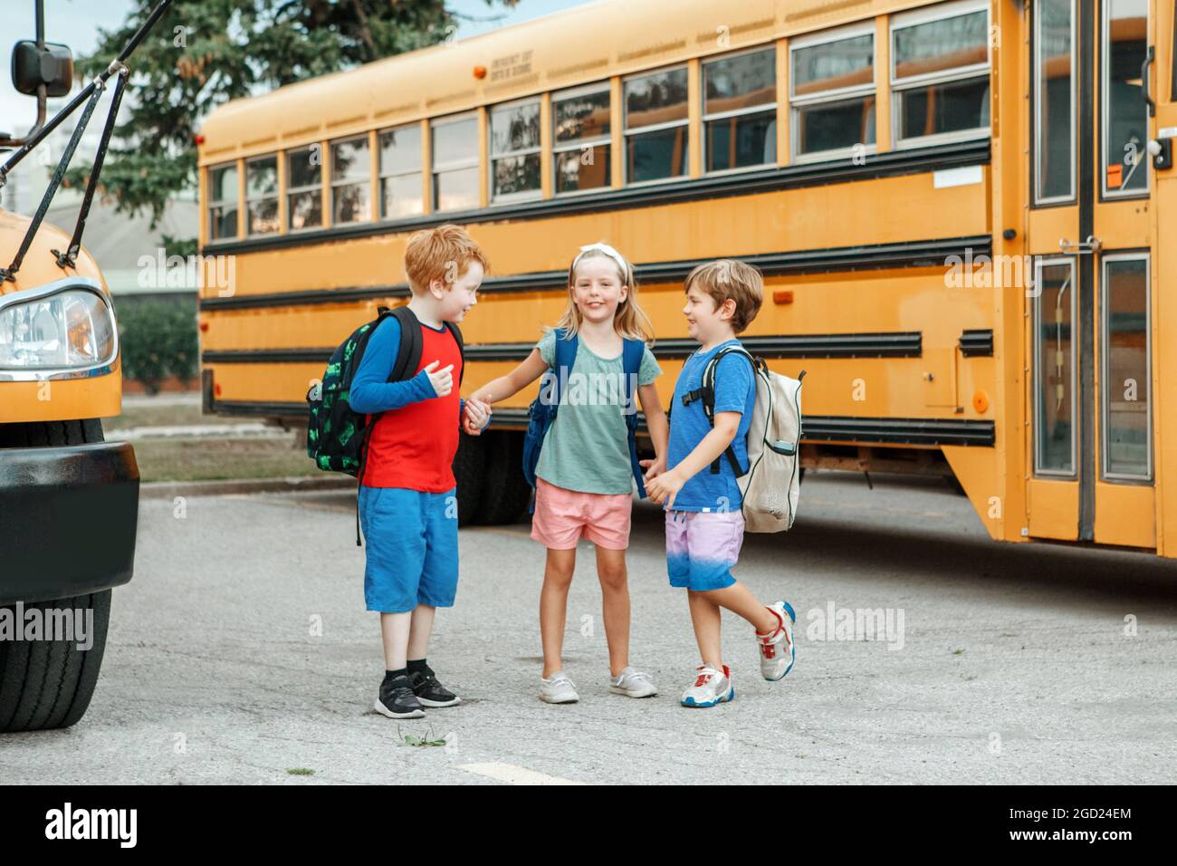 Children boys and girl kids students standing and talking near yellow ...