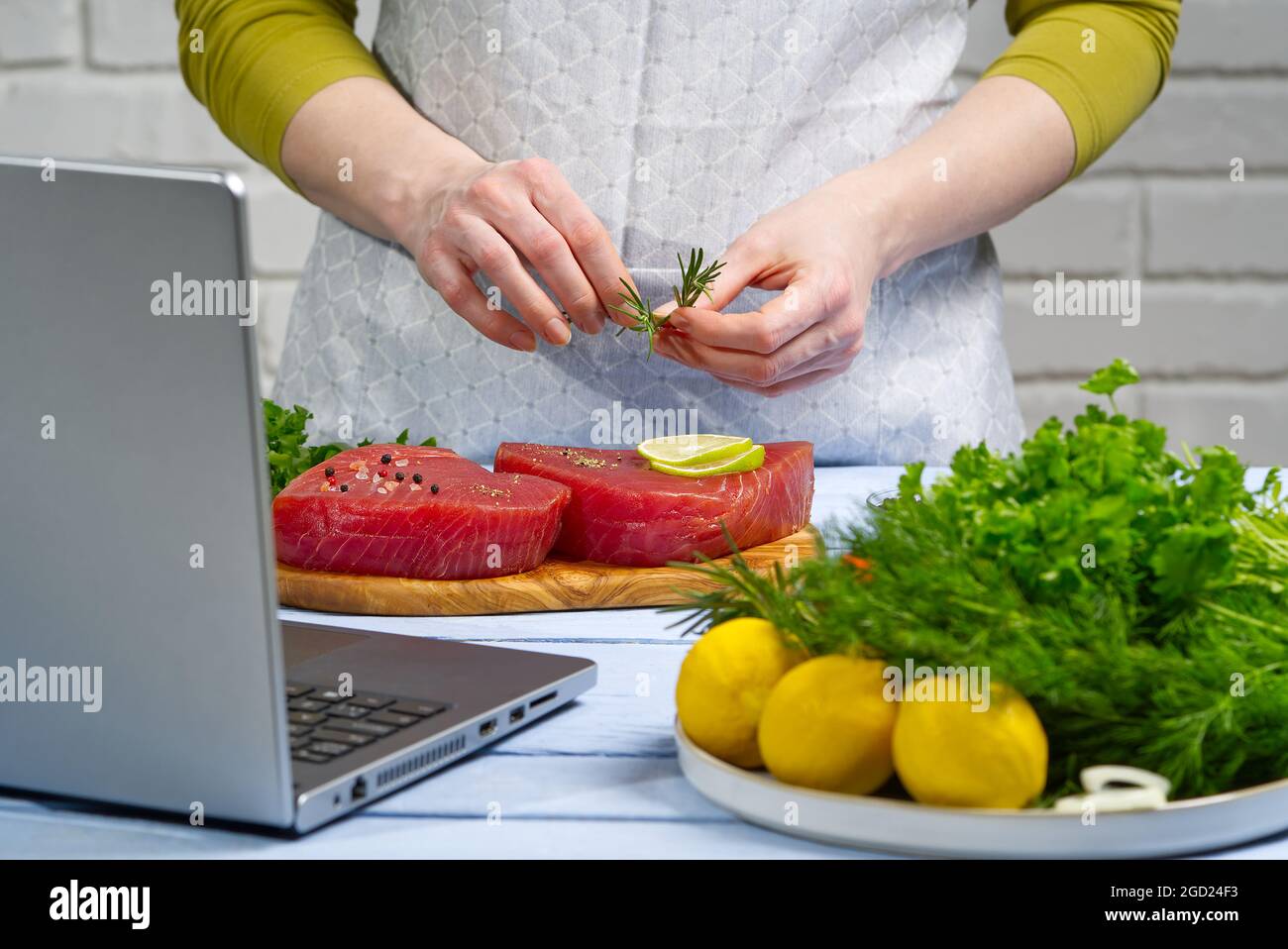 cooking and computer laptop concept. cooking woman in kitchen with pc ...