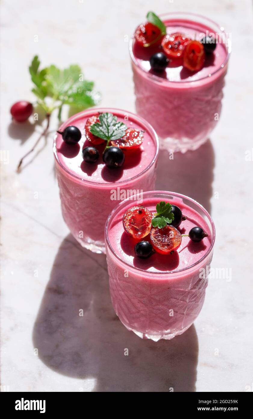 Berry mousse garnished with currants and gooseberries on a marble ...