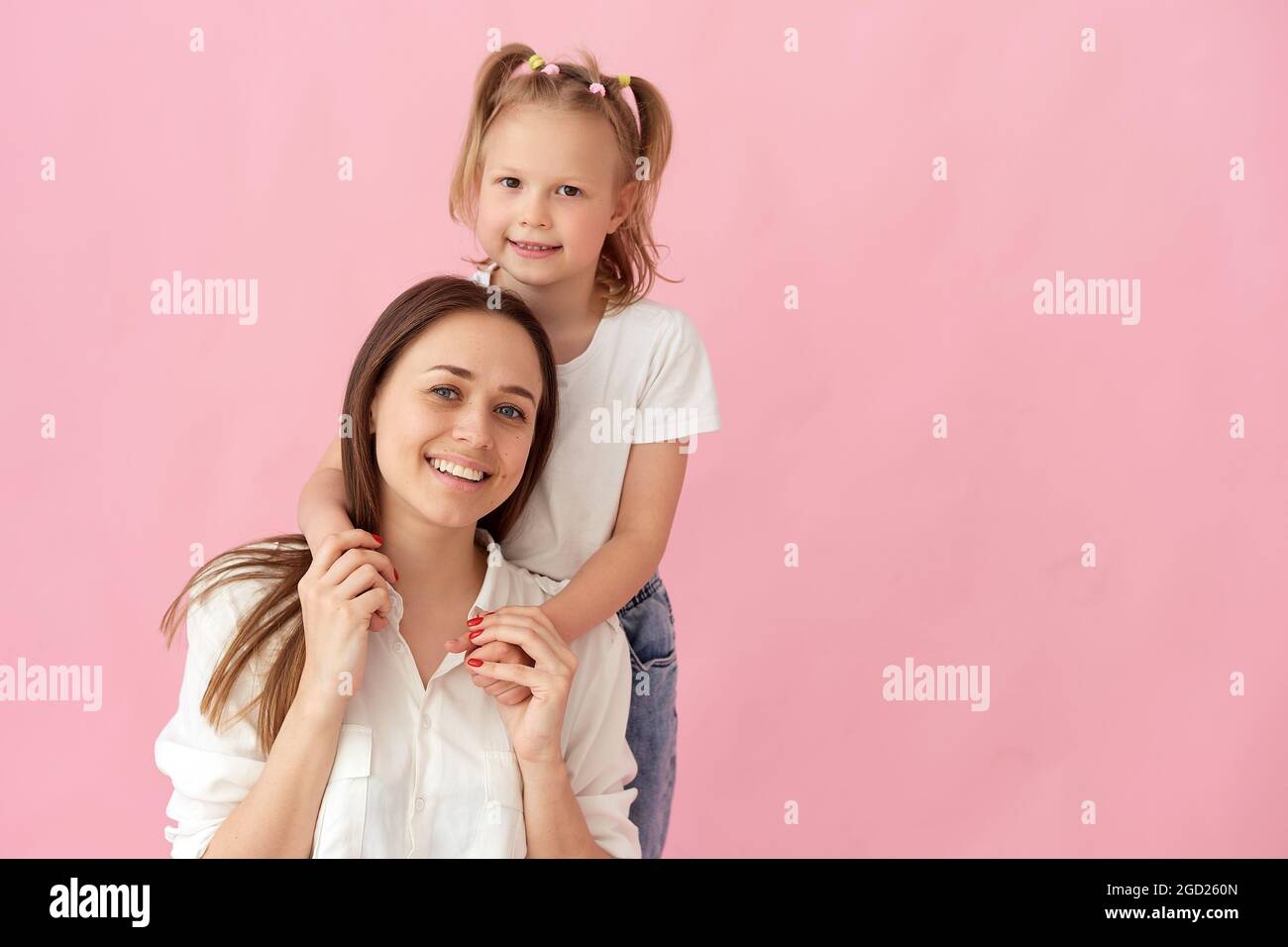 Close up photo of a beautiful young mother hugging her little daughter. best friends hugs ...