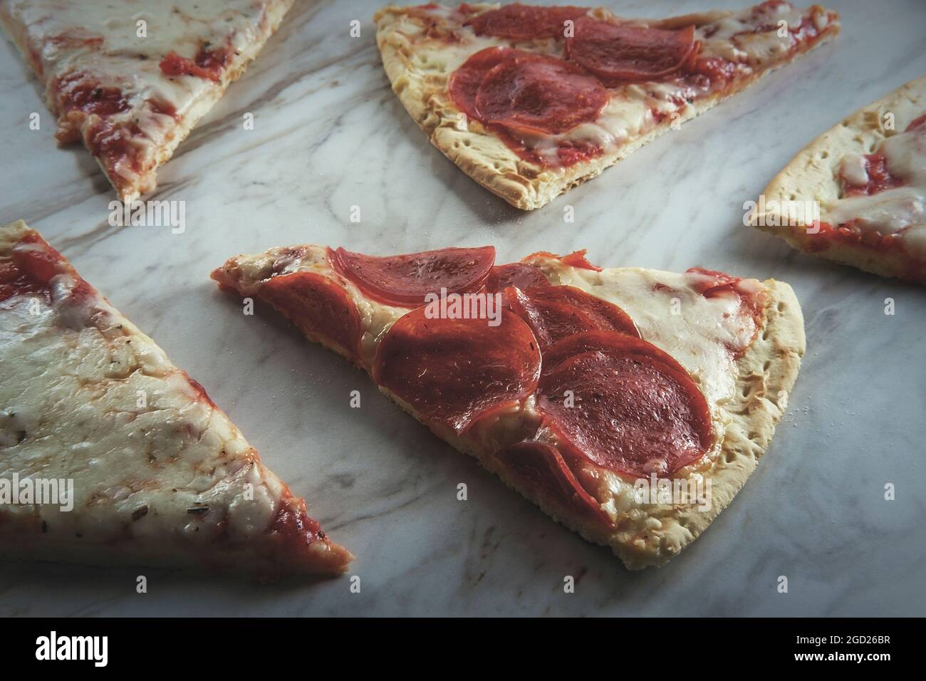 New York style pizza slices on marble kitchen table Stock Photo - Alamy