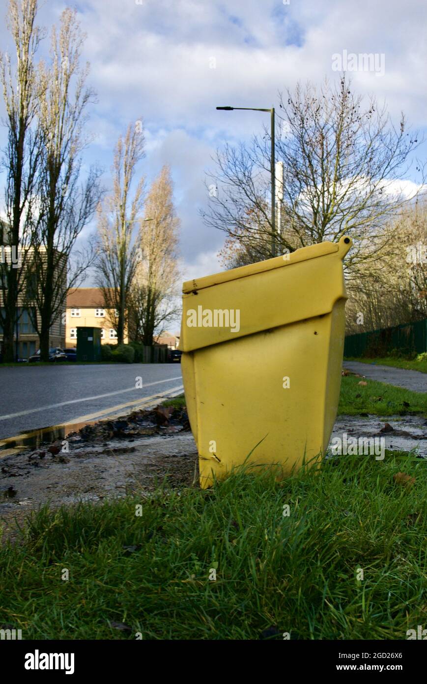 Vertical shot of a plastic garbage container on the side of a street ...